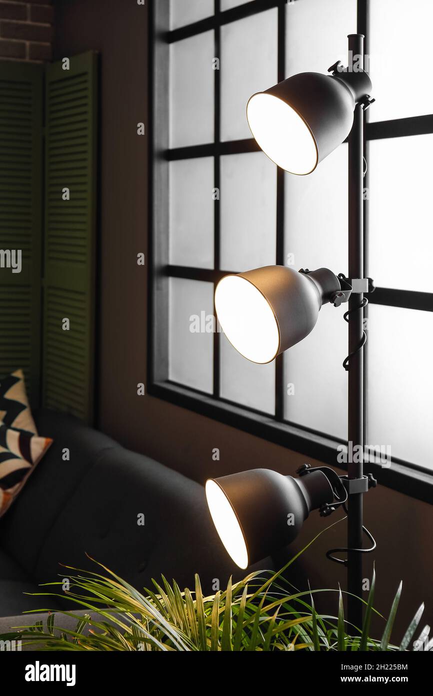 Glowing floor lamp near window in dark room Stock Photo - Alamy