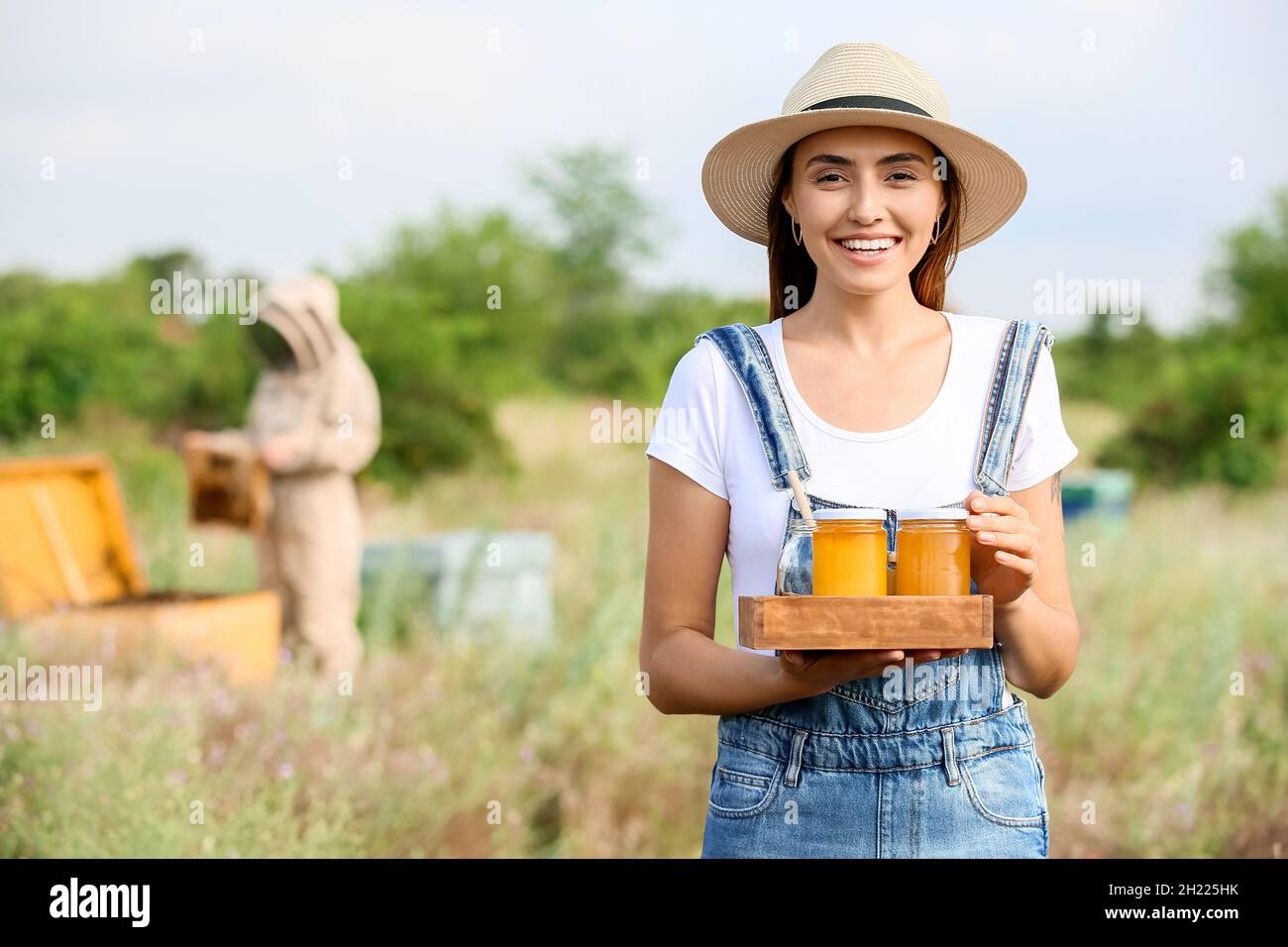 Female beekeeper with sweet honey at apiary Stock Photo - Alamy