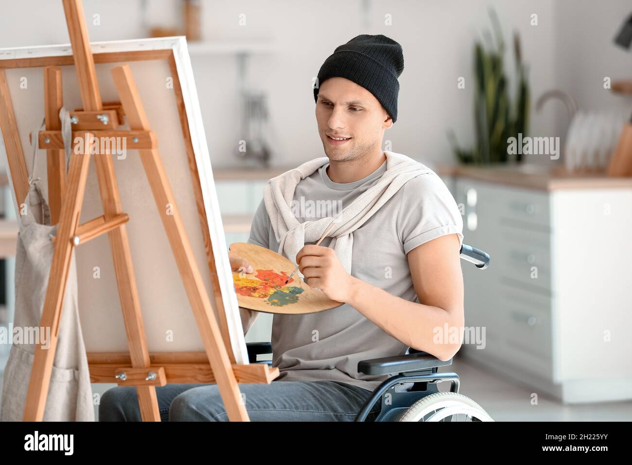 Young handicapped artist painting in workshop Stock Photo - Alamy