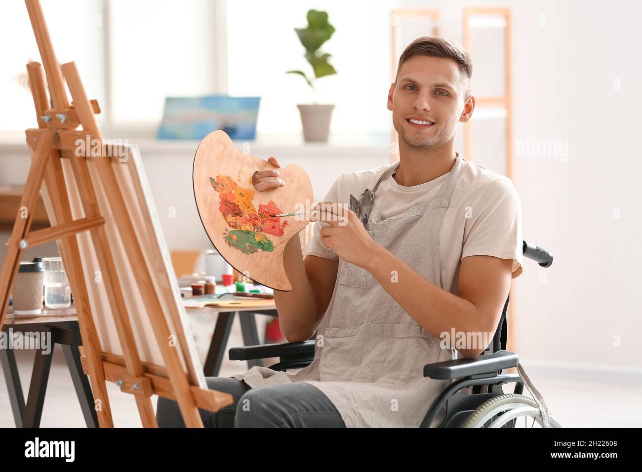 Young handicapped artist painting in workshop Stock Photo - Alamy