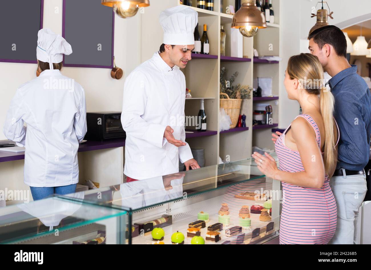 Cheerful pastry man is serving visitors Stock Photo - Alamy