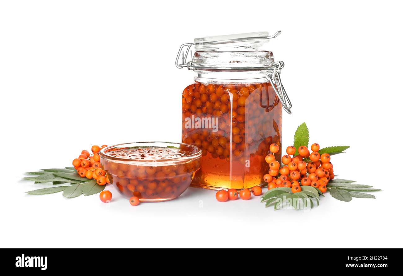 Bowl and jar of tasty rowan jam on white background Stock Photo - Alamy