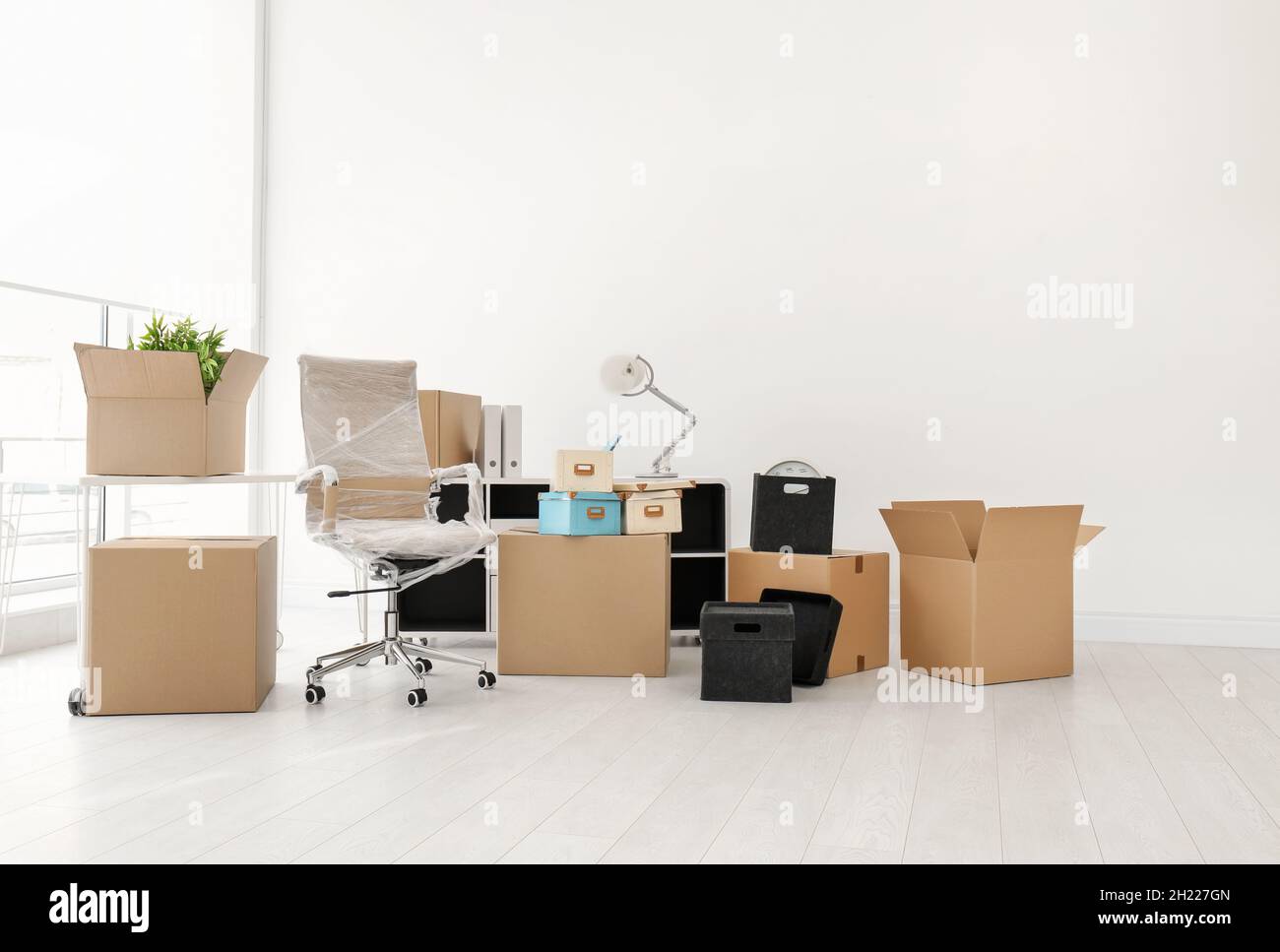 Moving boxes and furniture in new office Stock Photo - Alamy