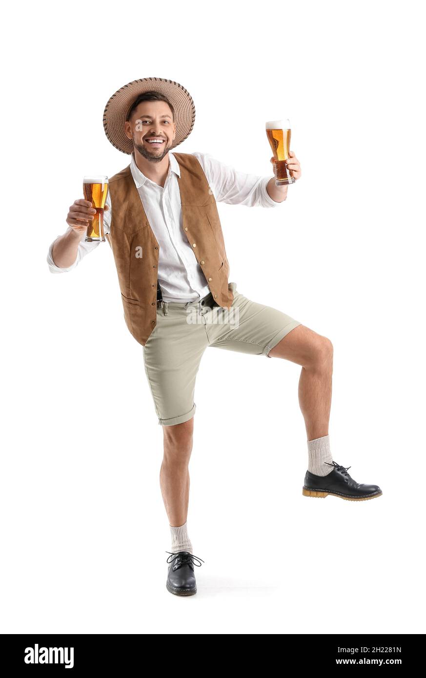Young man in traditional German clothes with beer on white background ...