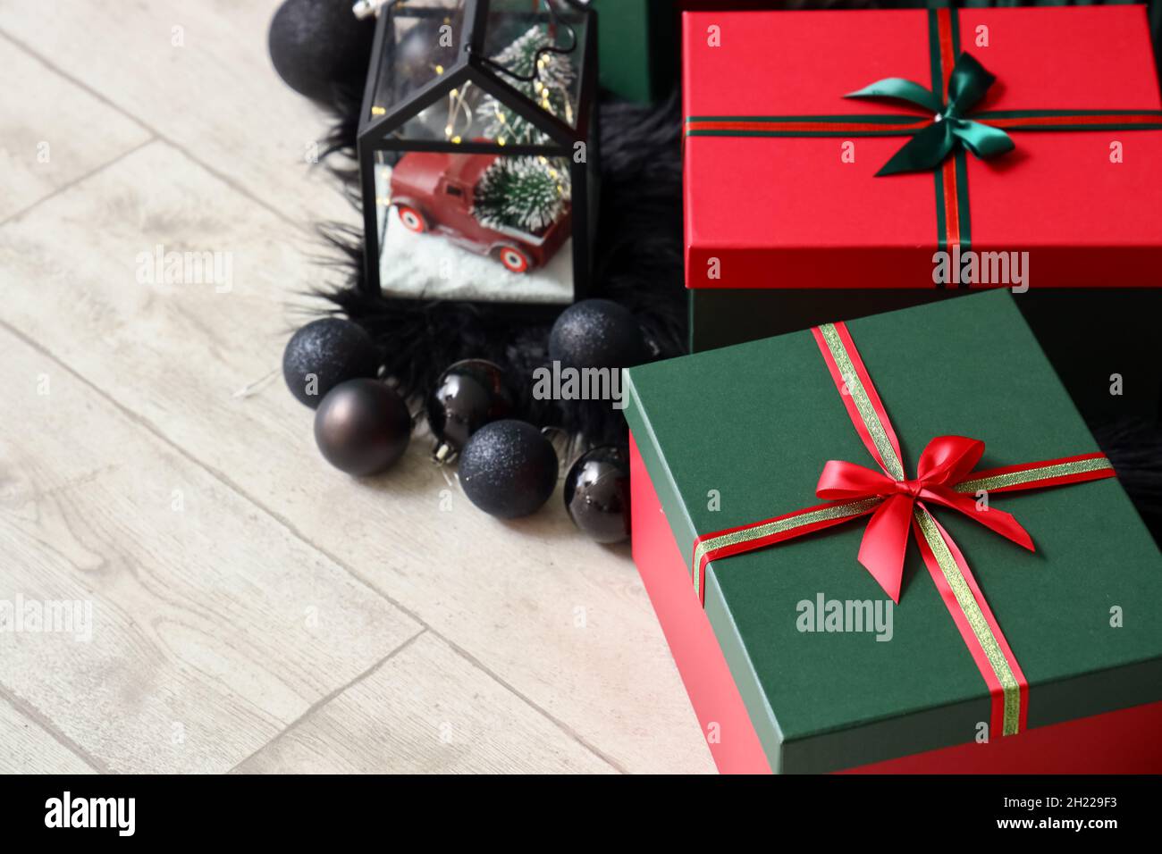 Christmas gift boxes on floor in room, closeup Stock Photo - Alamy