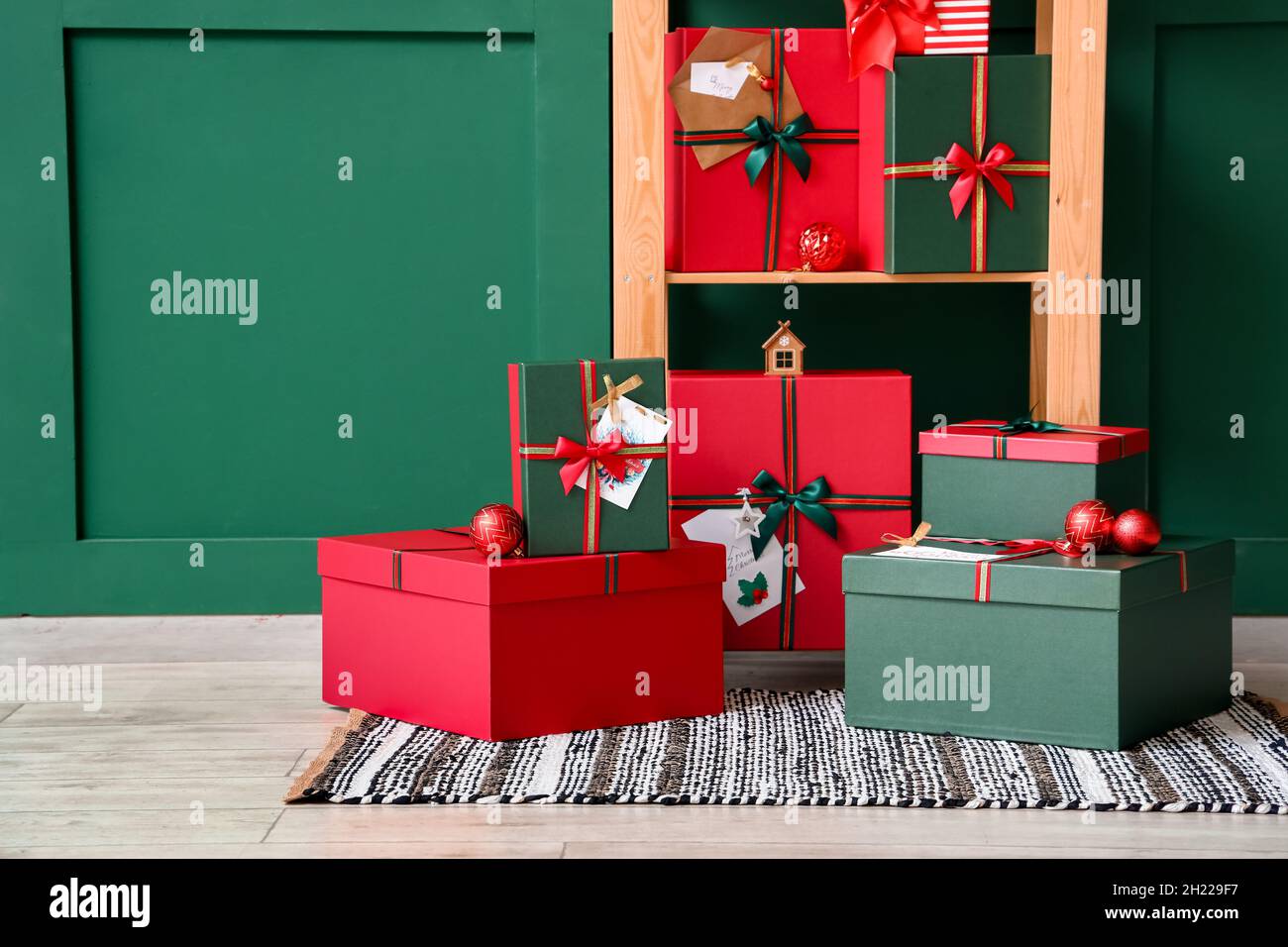 Christmas gift boxes and shelving unit near green wall Stock Photo - Alamy