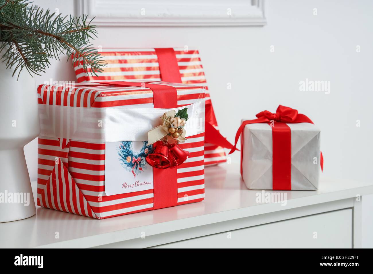 Christmas gift boxes on shelf near light wall Stock Photo - Alamy