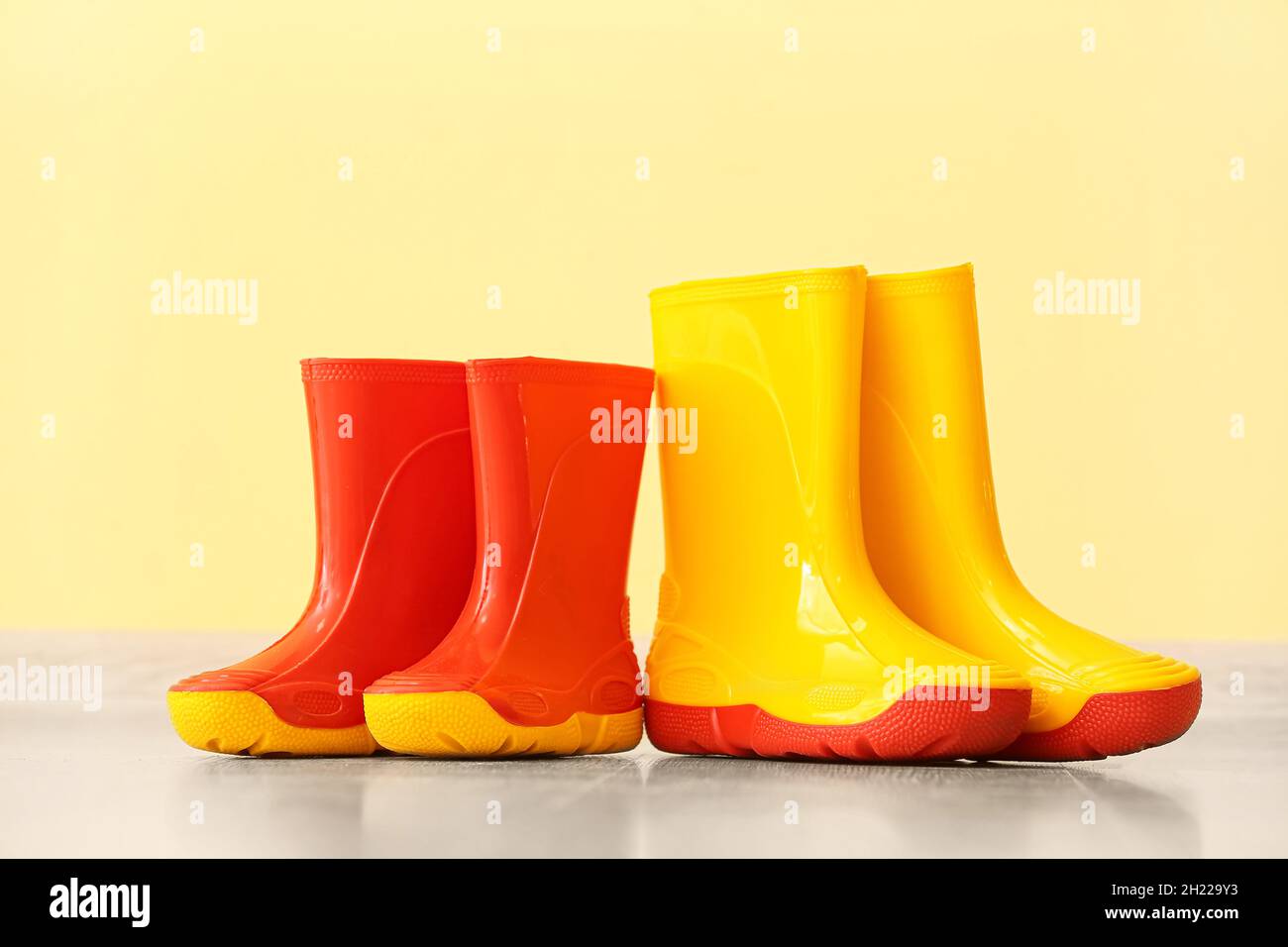 Colorful rubber boots near color wall Stock Photo - Alamy