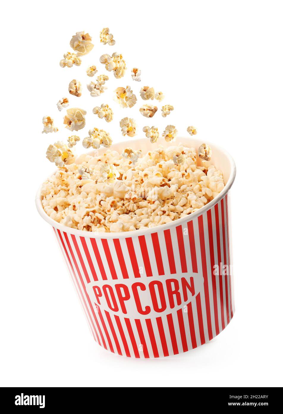 Delicious popcorn falling into red paper bucket on white background ...