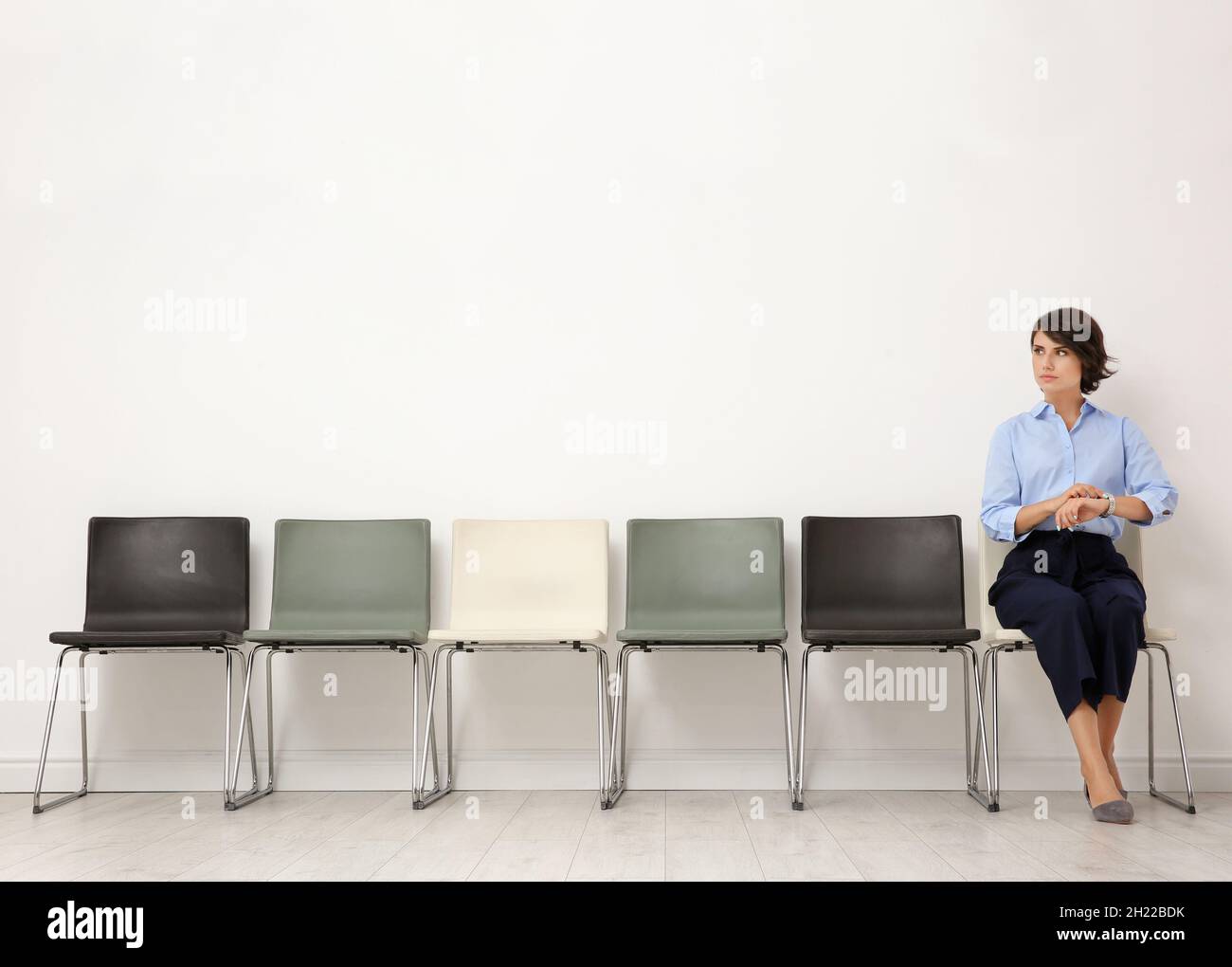 Young woman sitting on chair and waiting for job interview Stock Photo ...