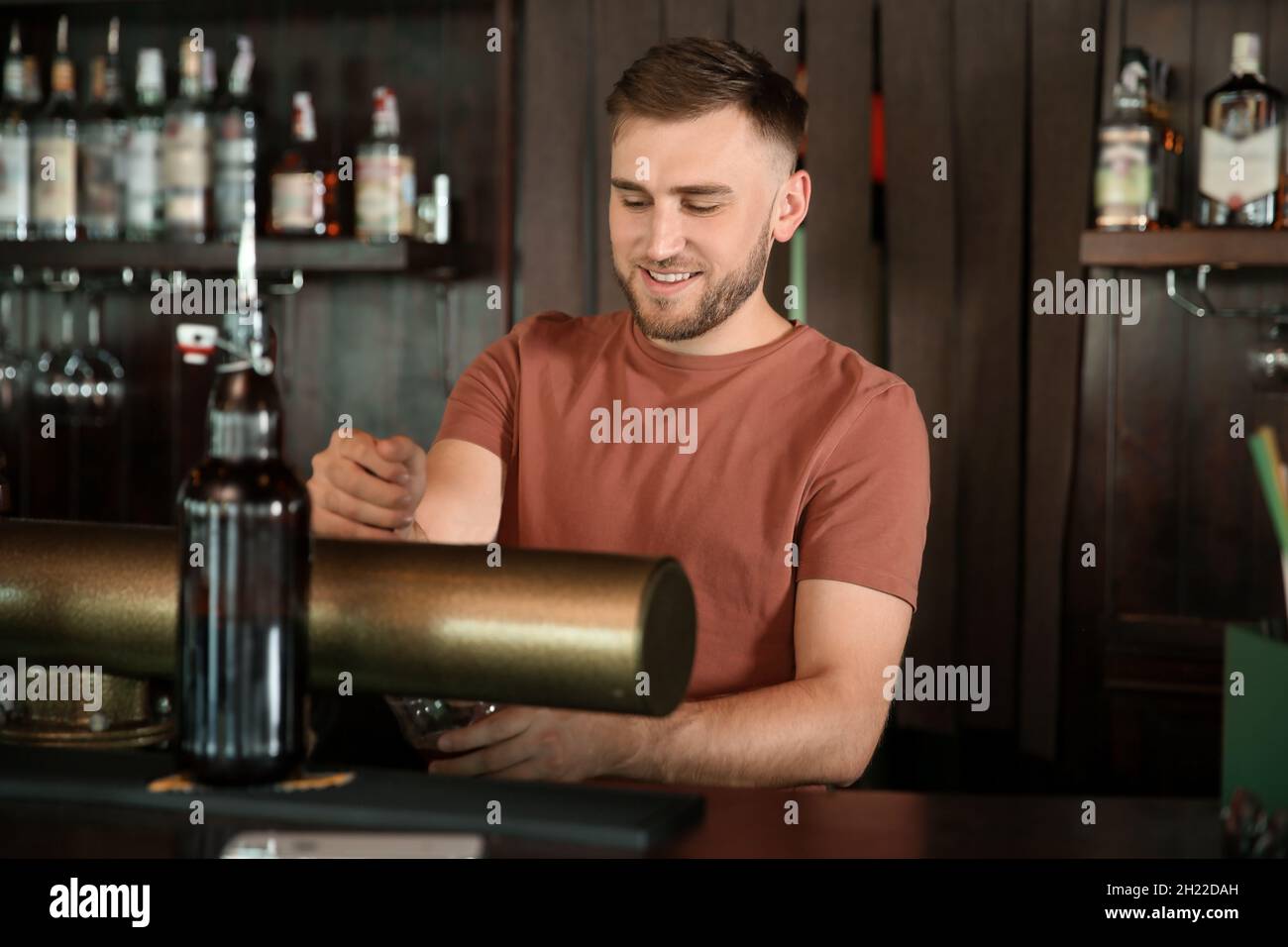 Bartender working at beer tap in pub Stock Photo - Alamy