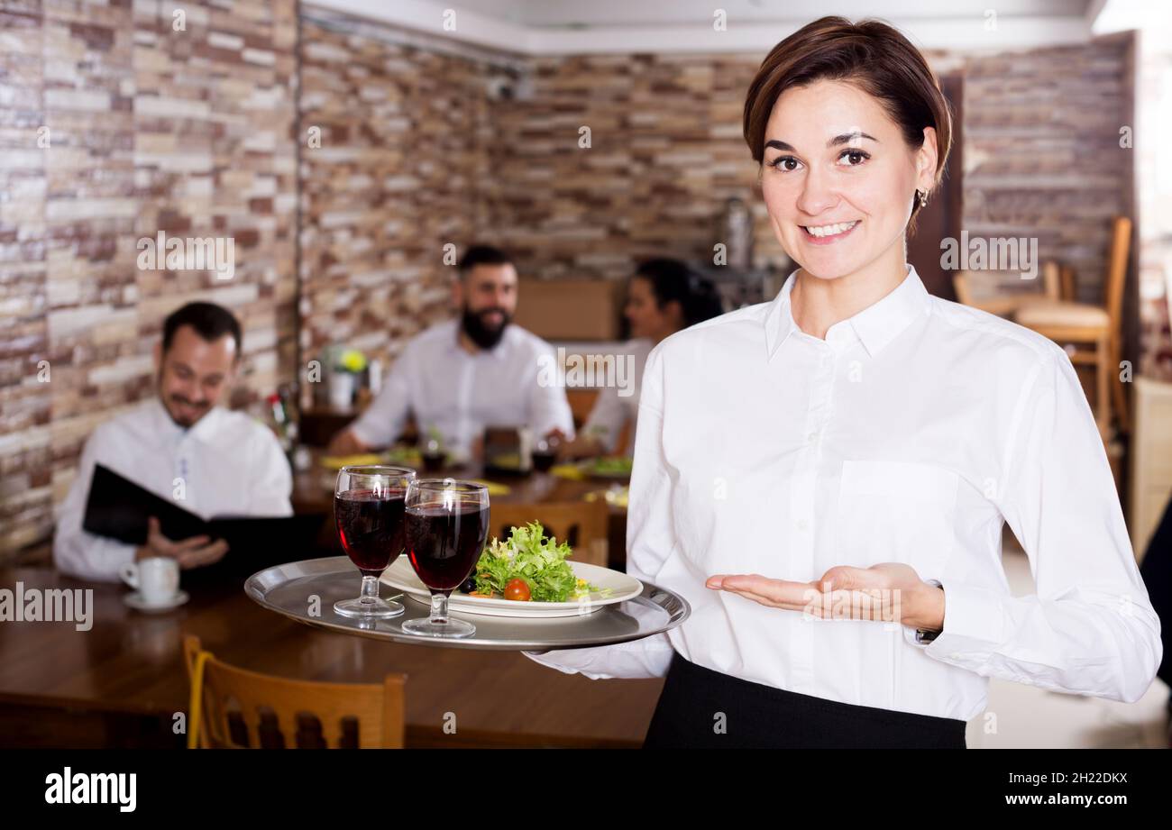 Female waiter showing country restaurant Stock Photo - Alamy