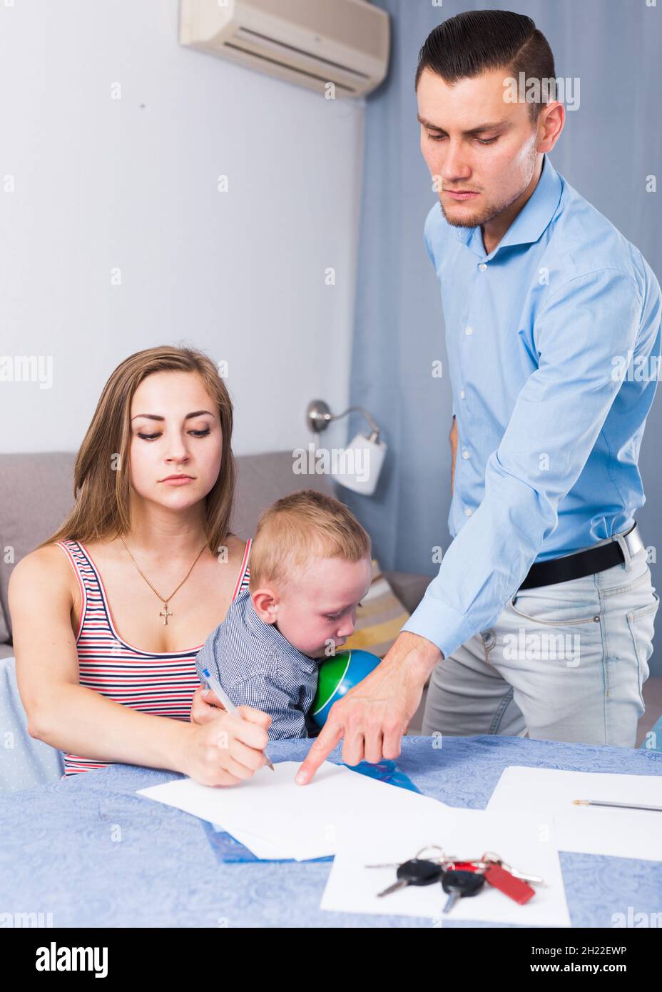 Sad woman with crying boy signing documents Stock Photo - Alamy