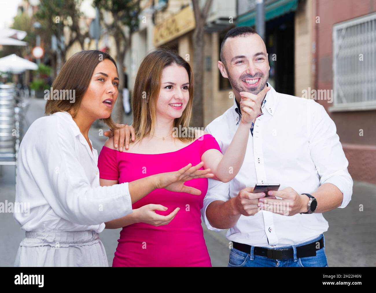 Smiling girls are pointing the way for young stranger Stock Photo - Alamy