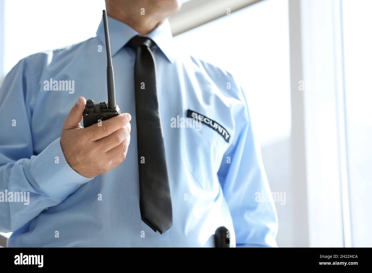 Male security guard with portable radio transmitter indoors Stock Photo ...