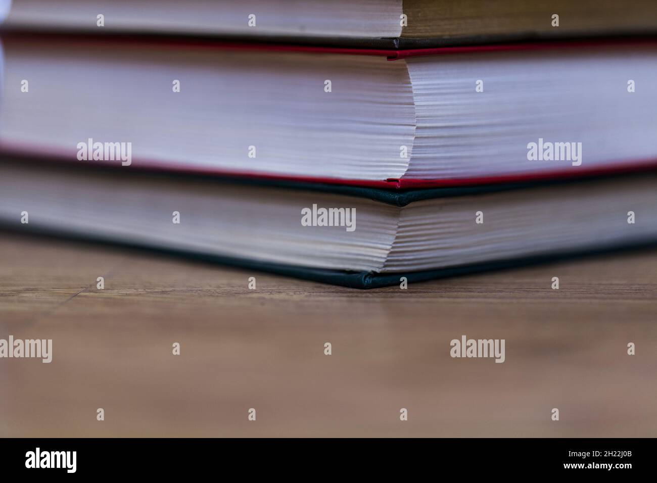 Closeup shot of piled books on a wooden surface Stock Photo - Alamy