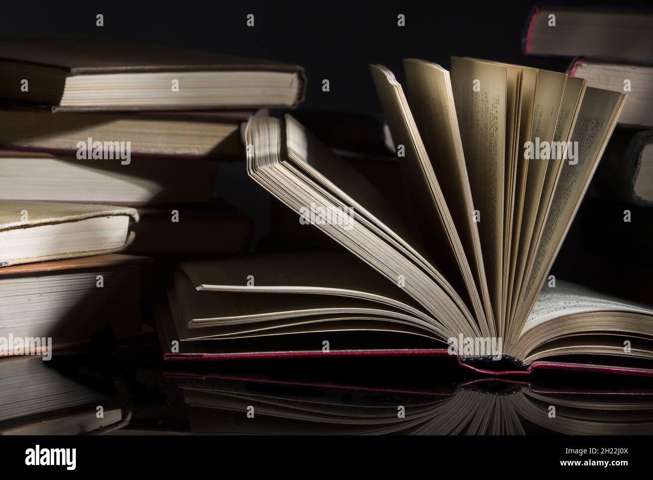 Closeup shot scanned books on a smooth surface isolated on a dark ...