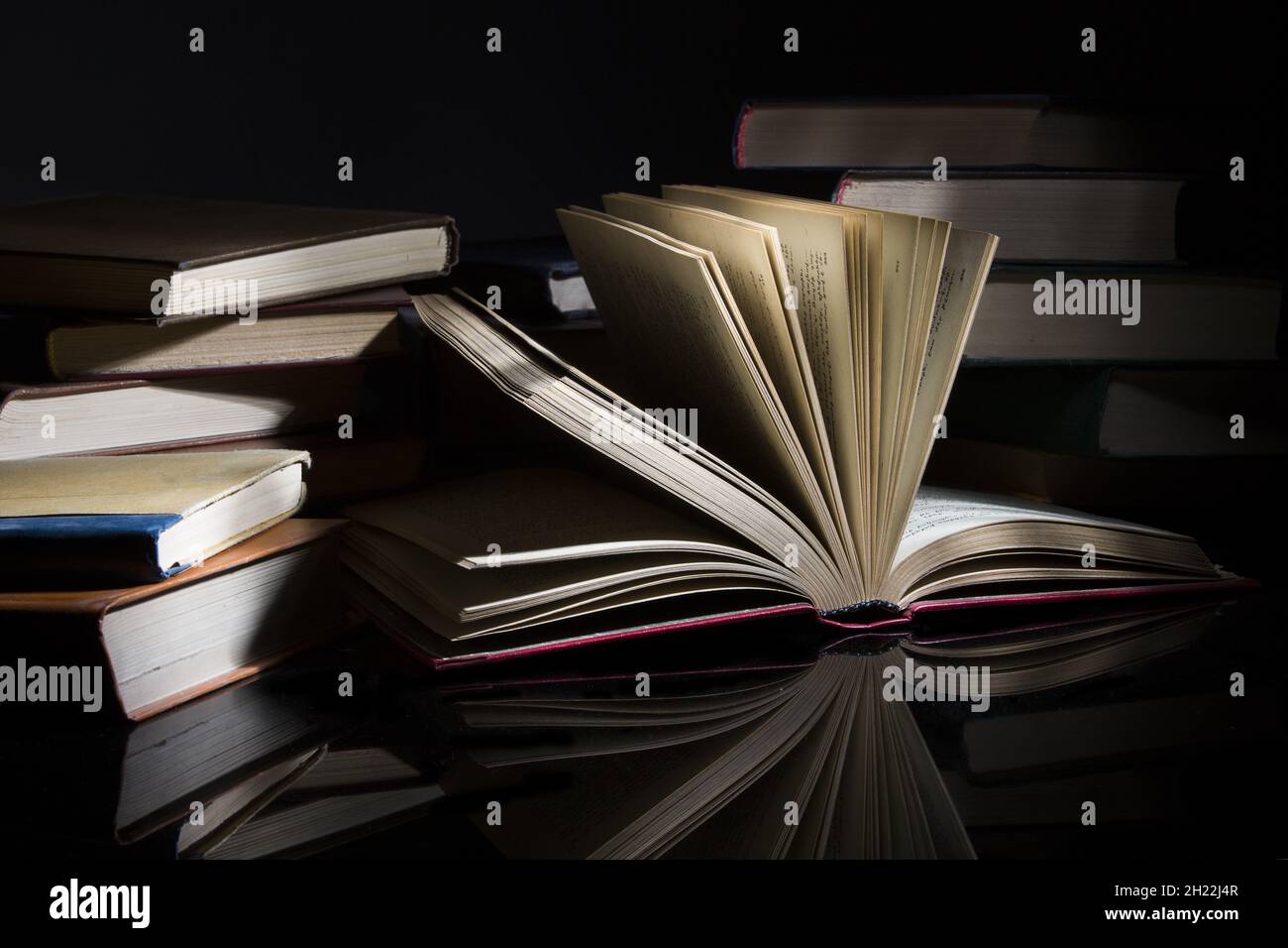 Closeup shot scanned books on a smooth surface isolated on a dark ...