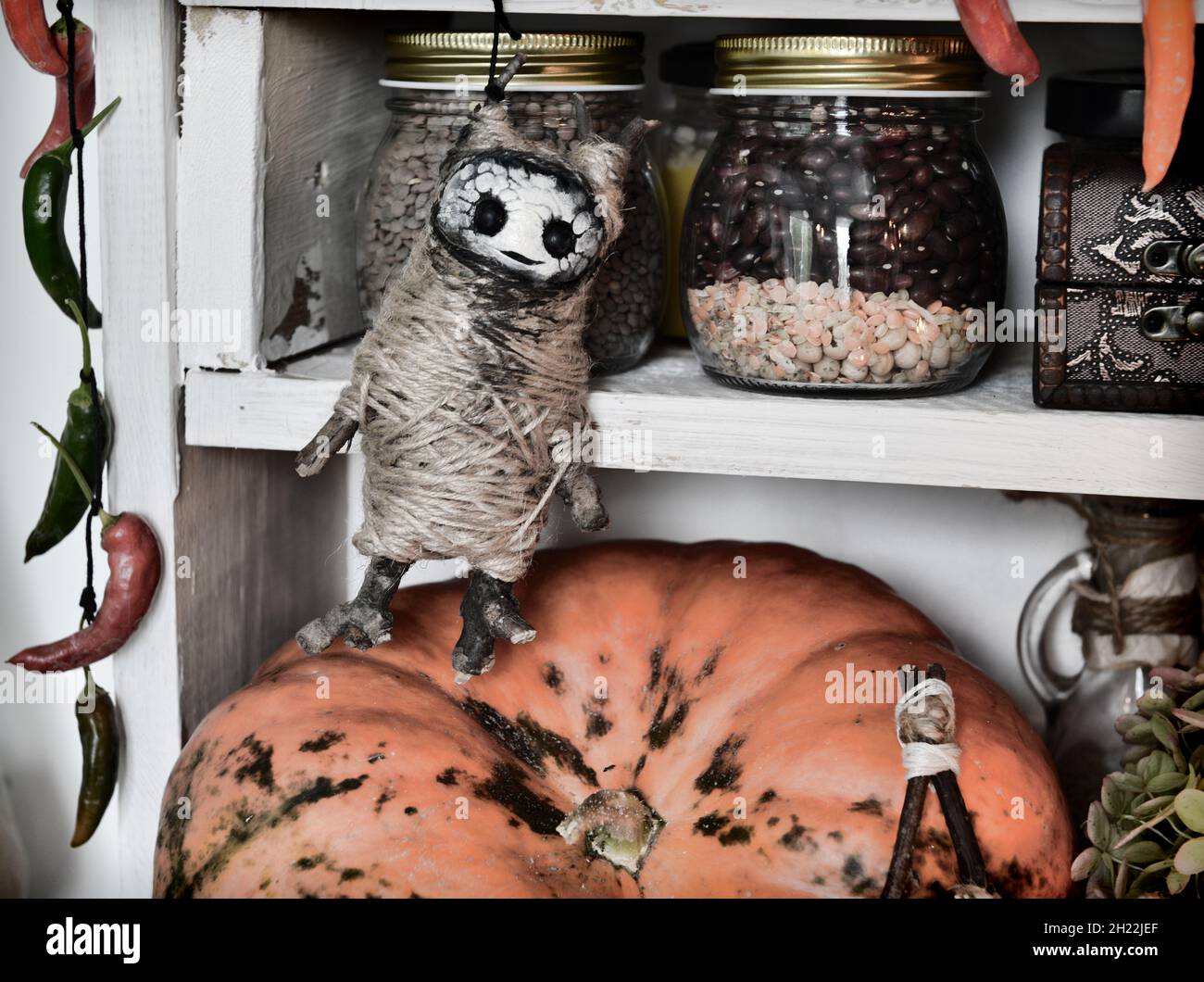 Vintage kitchen still life with voodoo doll, pumpkin, old bottles and ...