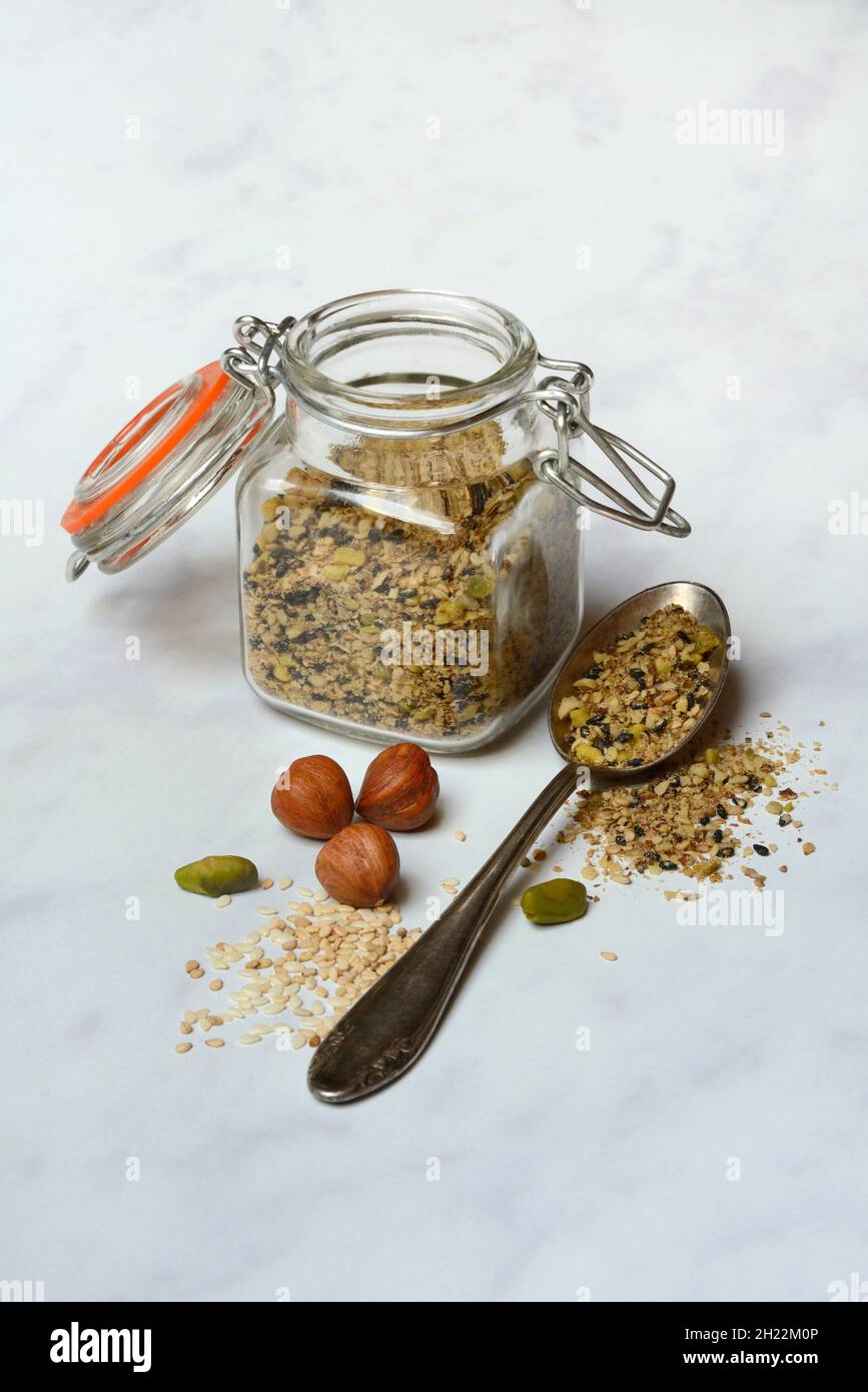Dukkah, Arabic spice mix in glass container and spoon, nuts Stock Photo ...