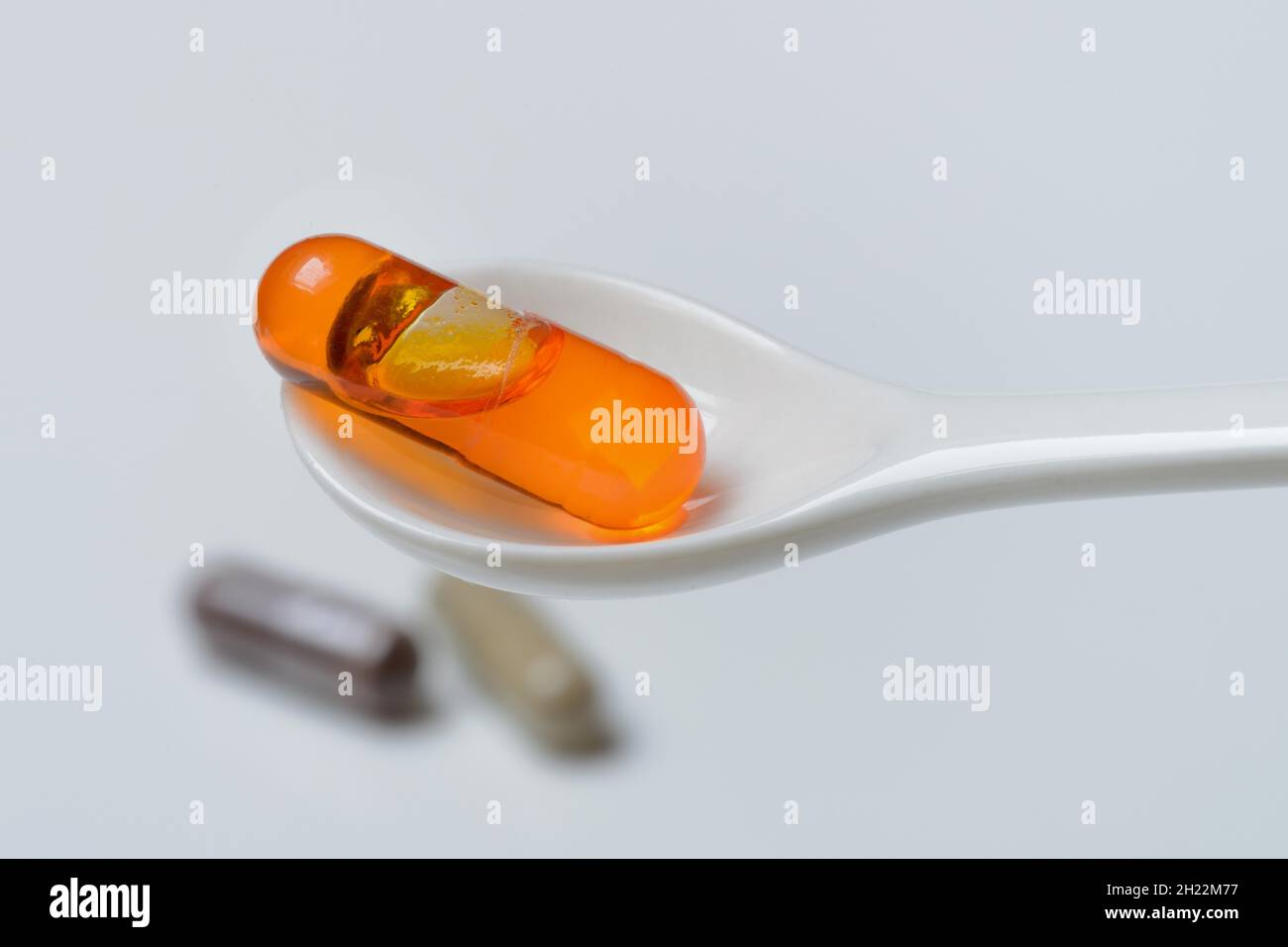 Capsule with omega-3 fatty acids in spoon Stock Photo - Alamy