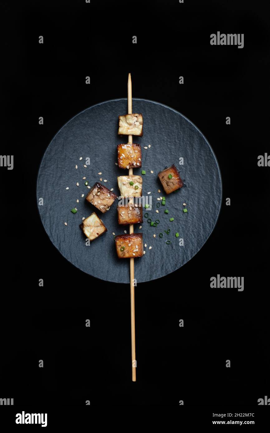 Fried tofu cubes with wooden skewer on plate Stock Photo - Alamy