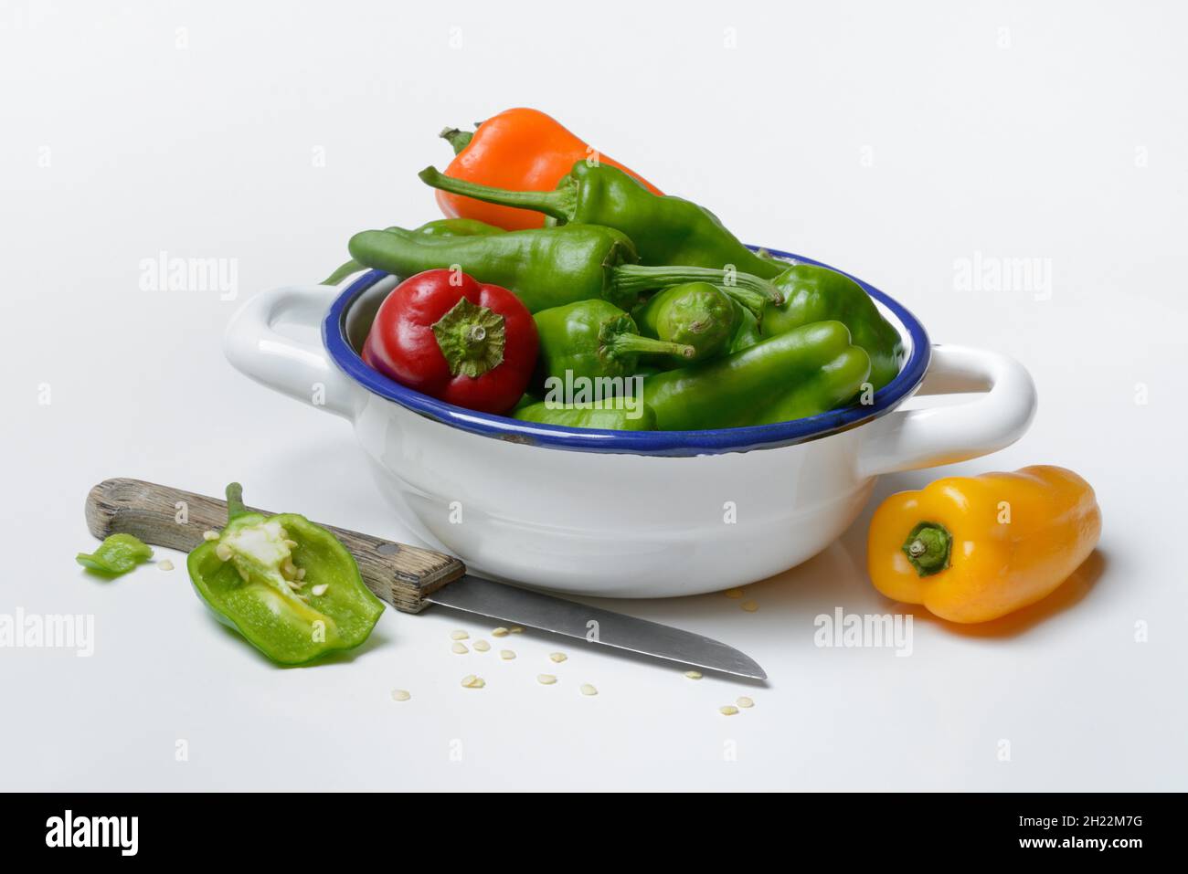Different coloured chillies in bowl with knife, paprika Stock Photo - Alamy