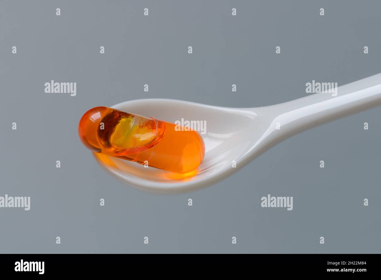 Capsule with omega-3 fatty acids in spoon Stock Photo - Alamy