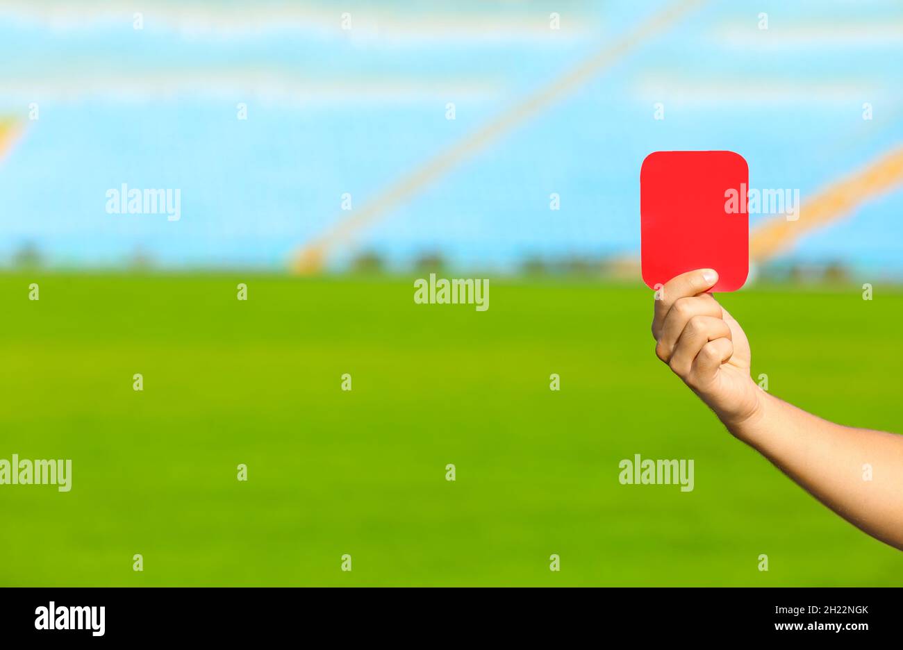 Football referee showing red card at stadium, closeup with space for ...