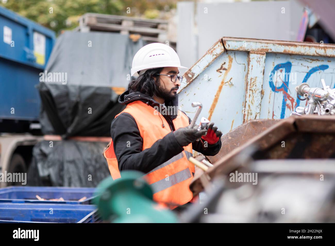 Technician with beard and helmet working in a recycling yard, Freiburg ...