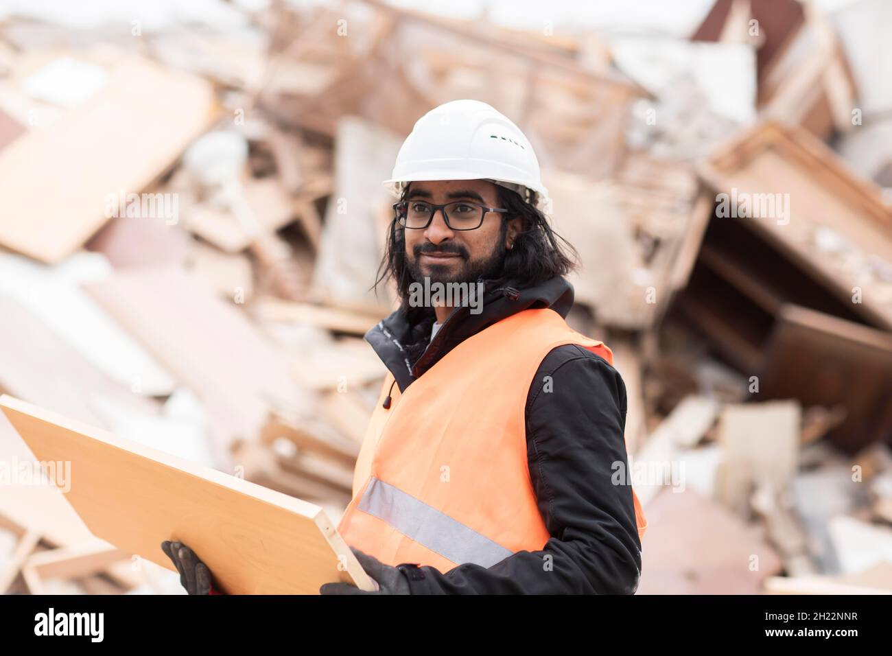 Technician with beard and helmet working in a recycling yard, Freiburg ...