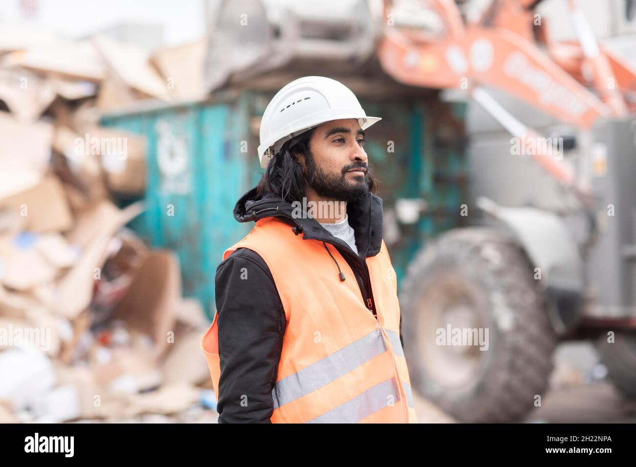 Technician with beard and helmet working in a recycling yard, Freiburg ...