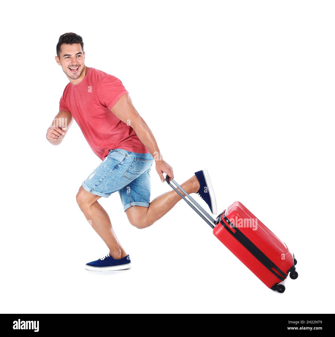 Young man running with suitcase on white background Stock Photo - Alamy