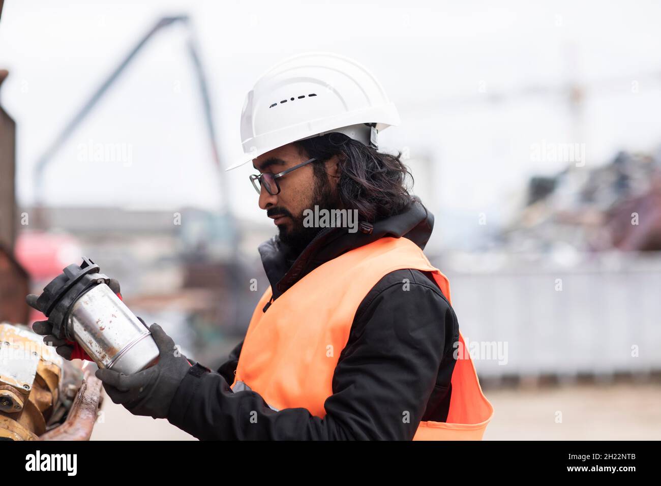 Technician with beard and helmet working in a recycling yard, Freiburg ...