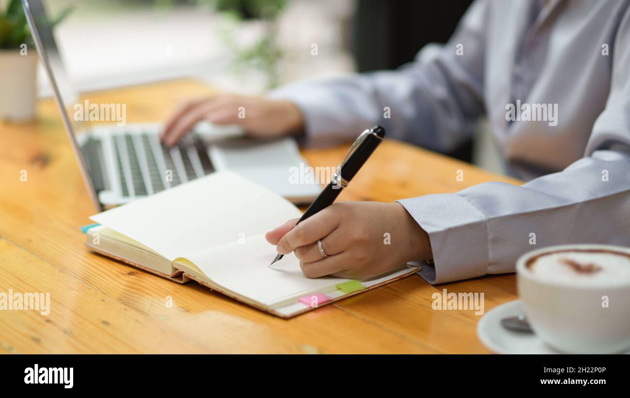 Close-up image of businesswoman taking some notes, jotting down ...