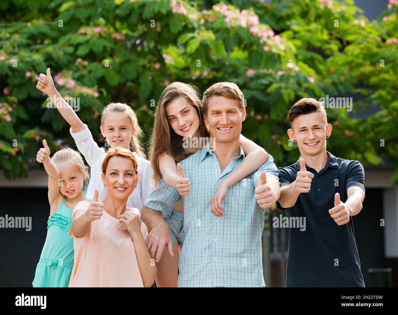 Portrait of large family of six standing and holding thumbs up Stock ...
