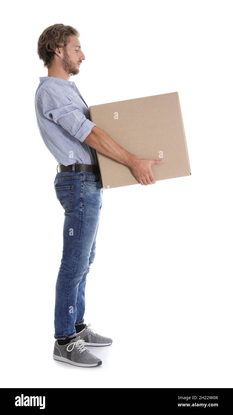 Full length portrait of young man carrying heavy cardboard box on white ...