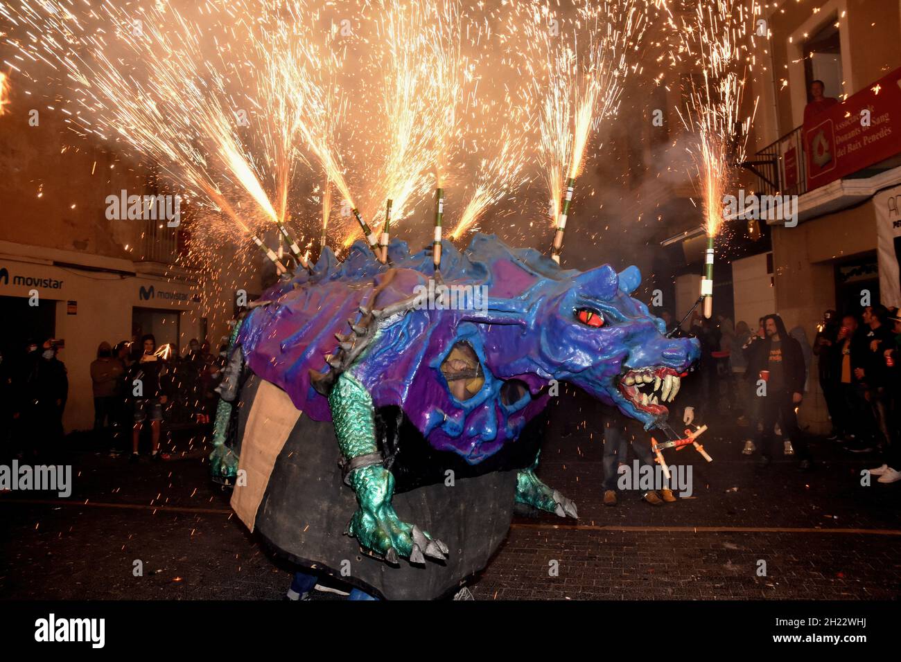 A person carries a creature in the shape of a devil with fire on its ...