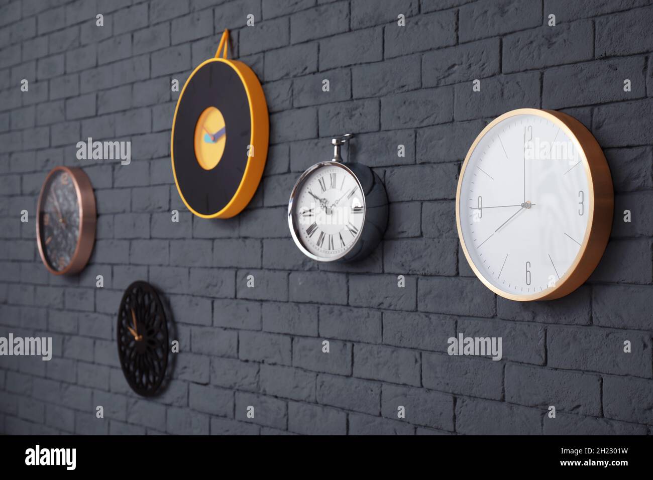 Different clocks on brick wall. Time concept Stock Photo - Alamy
