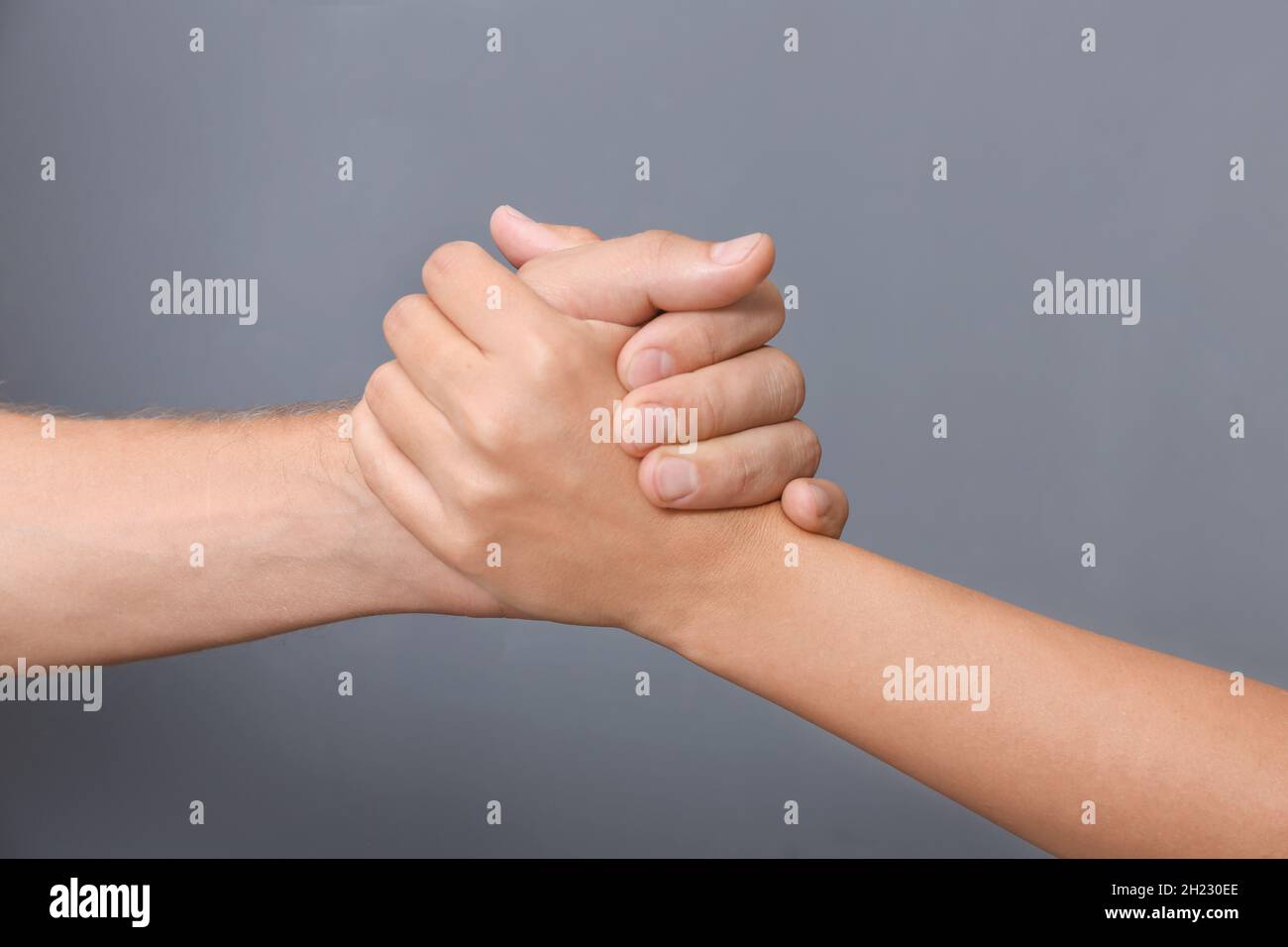 People holding hands together on gray background, closeup. Concept of ...