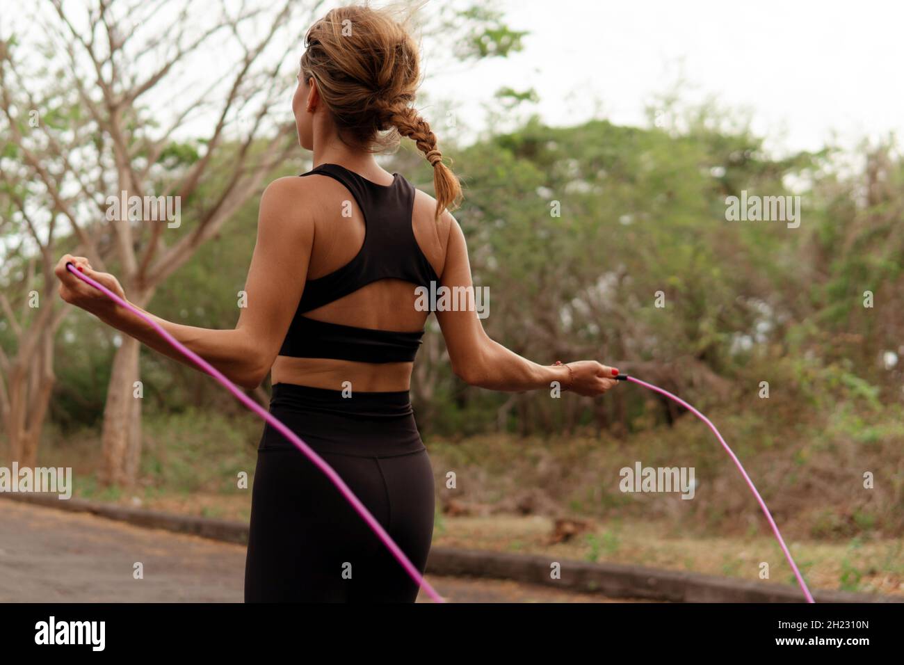 woman in black sportwear jumping rope. bali Stock Photo - Alamy