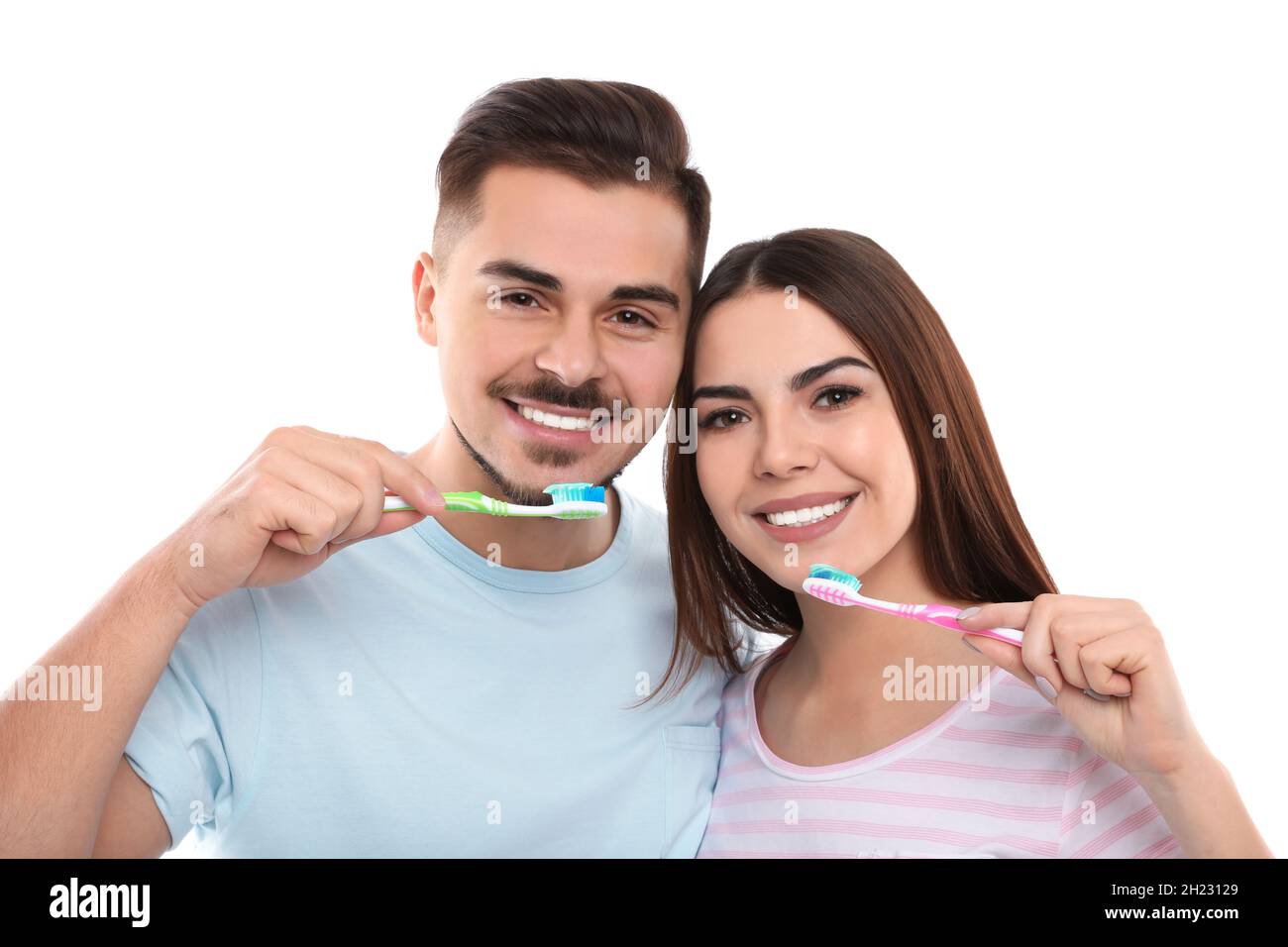 Happy couple brushing teeth on white background Stock Photo - Alamy