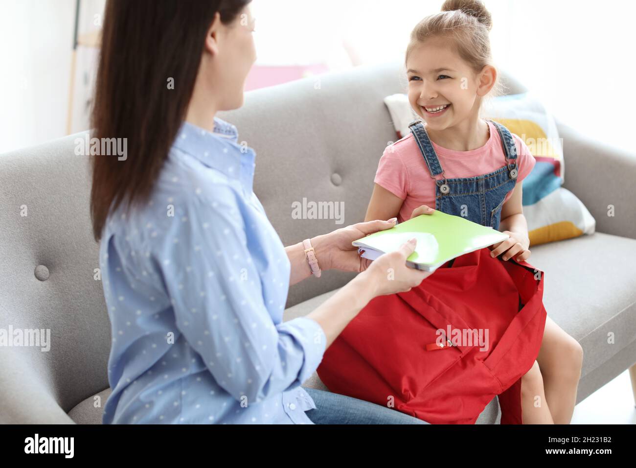 Young woman helping her little child get ready for school at home Stock ...