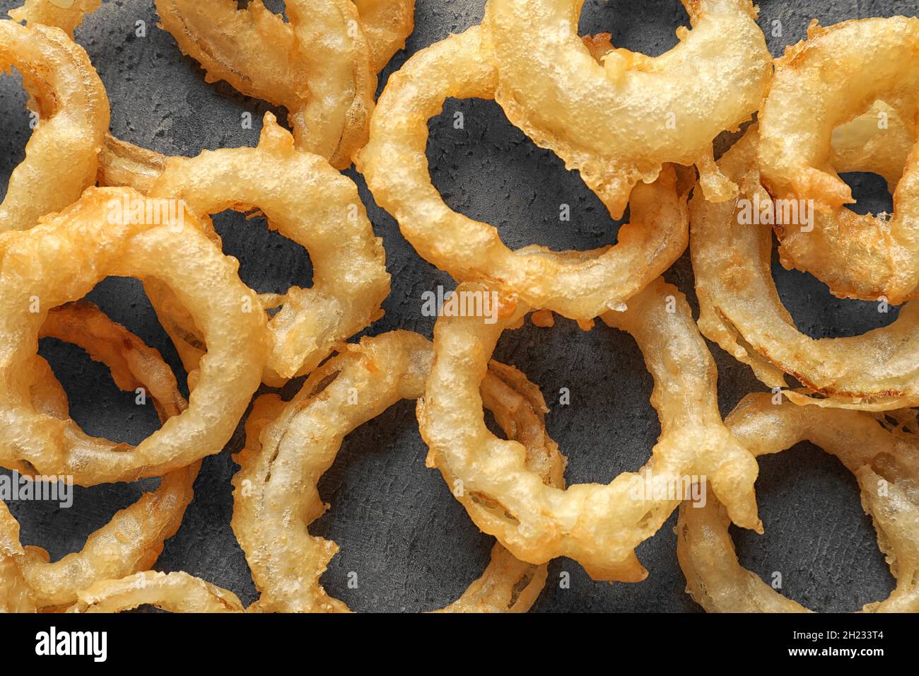 Delicious golden breaded and deep fried crispy onion rings on gray ...