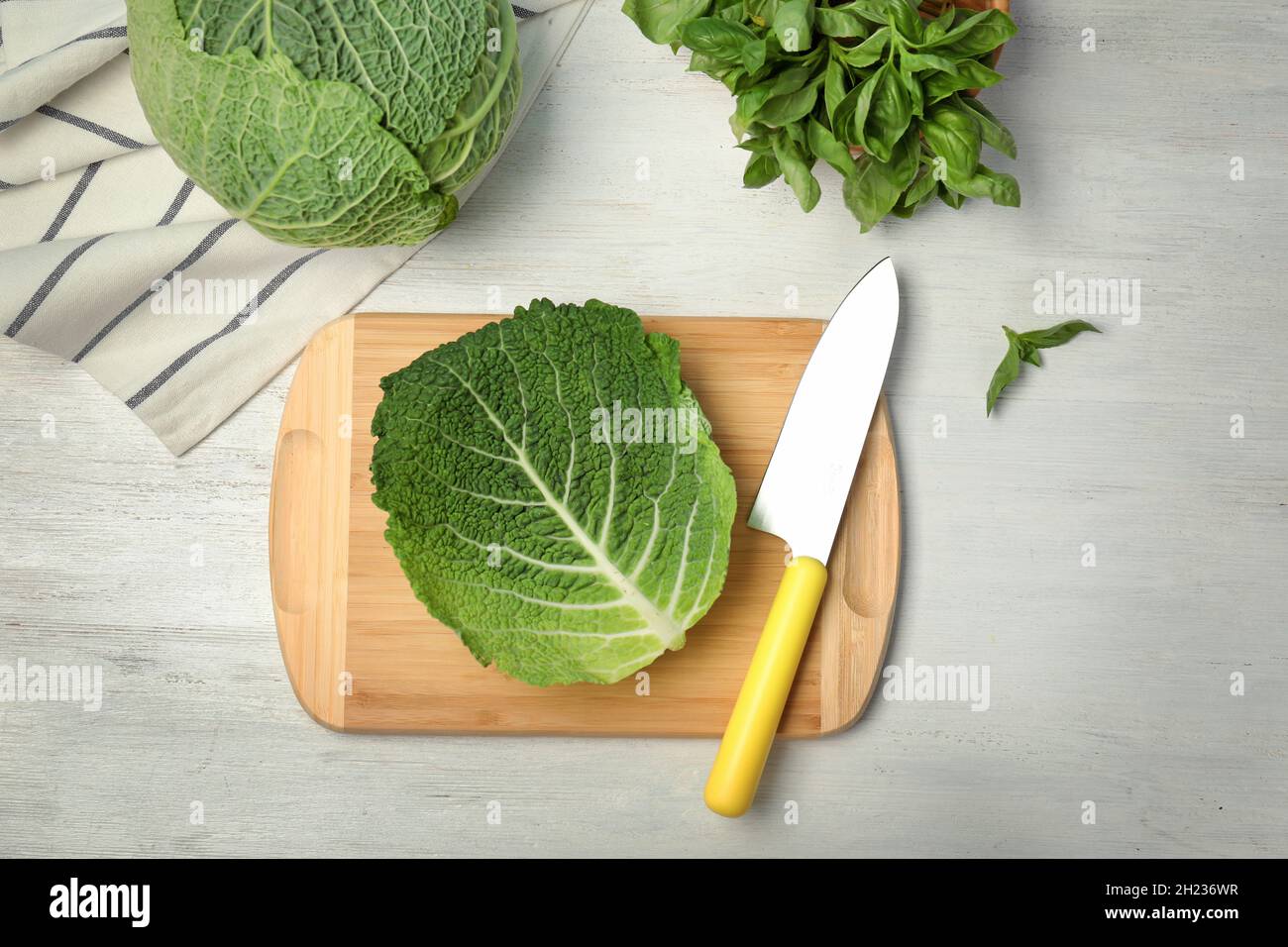 Flat lay composition with savoy cabbage and basil on white wooden ...