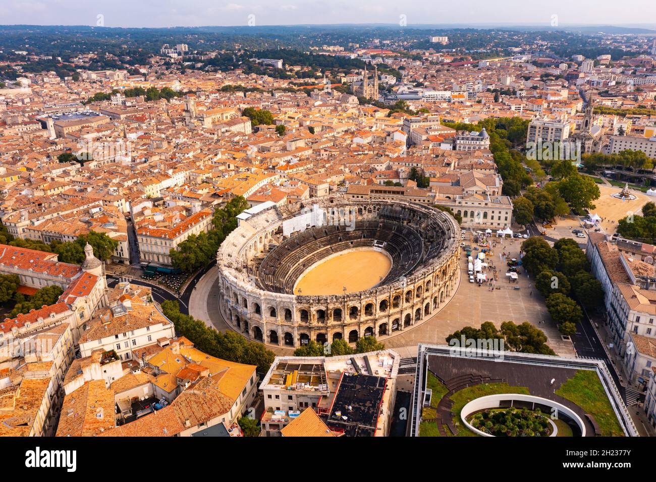 Aerial view of Roman amphitheatre on background with cityscape of Nimes ...