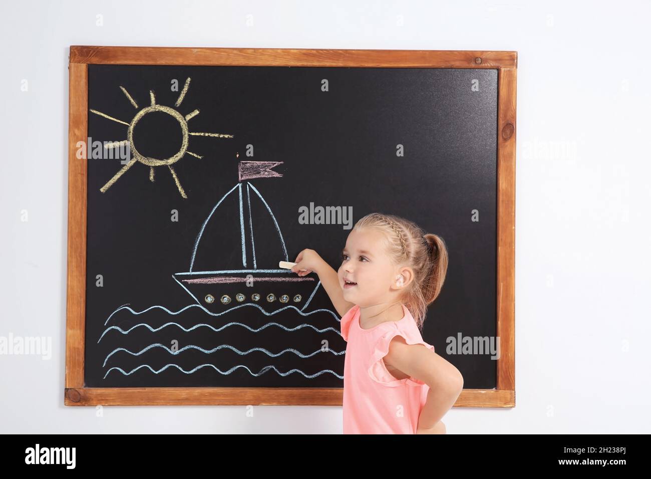 Little child drawing ship with colorful chalk on blackboard Stock Photo ...
