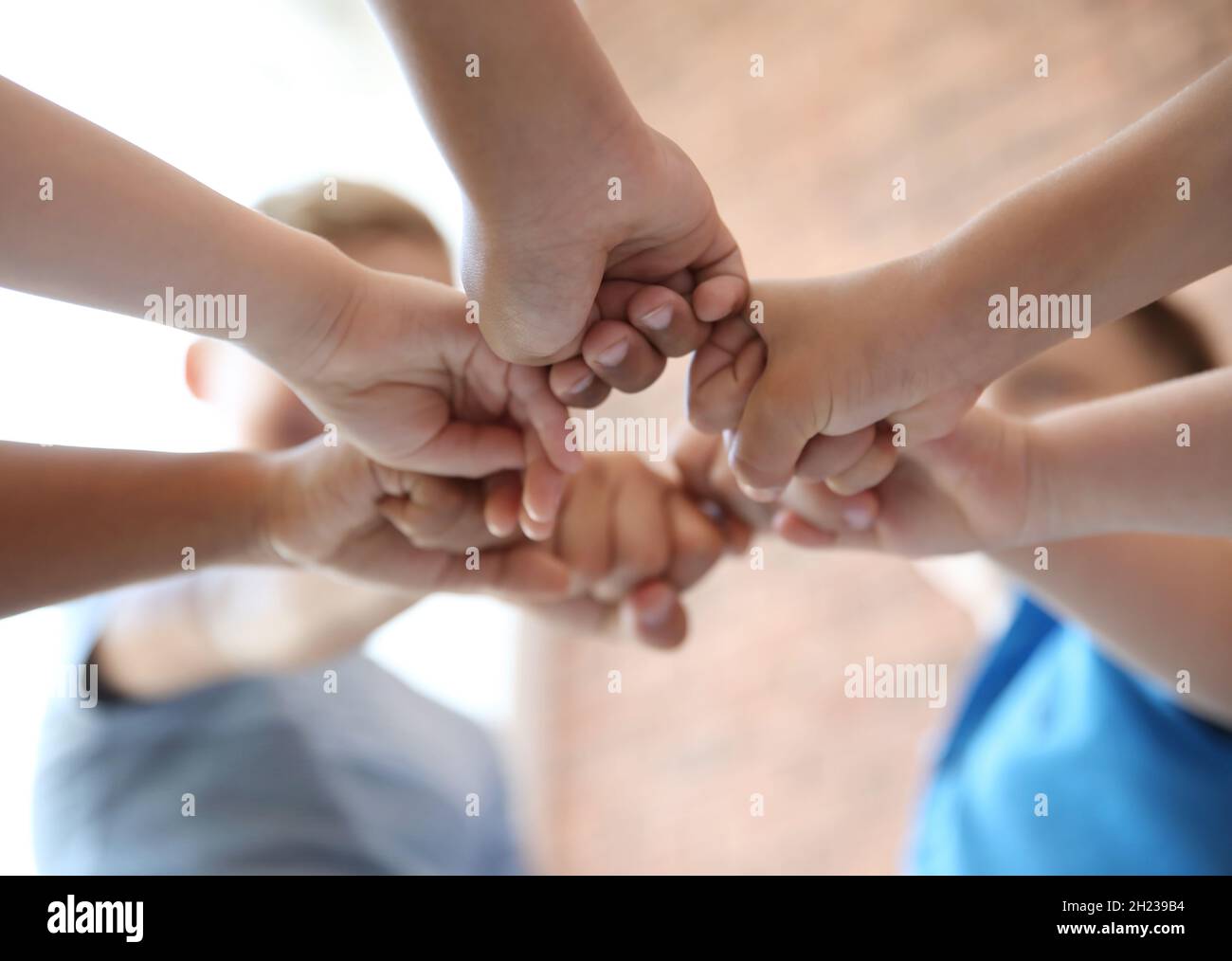 Little children putting their hands together on blurred background ...
