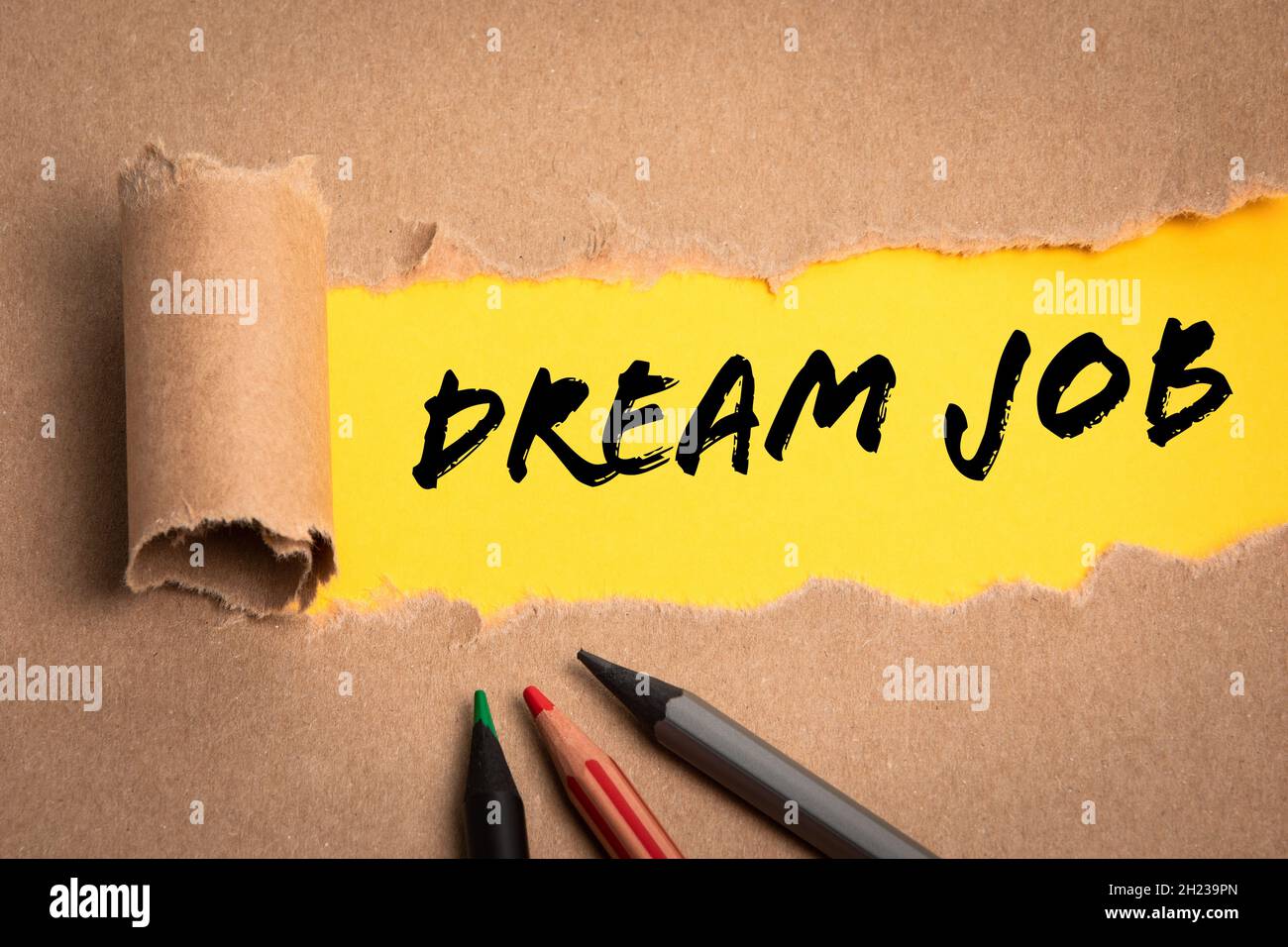 DREAM JOB. Torn cardboard and pencils on a yellow background Stock ...