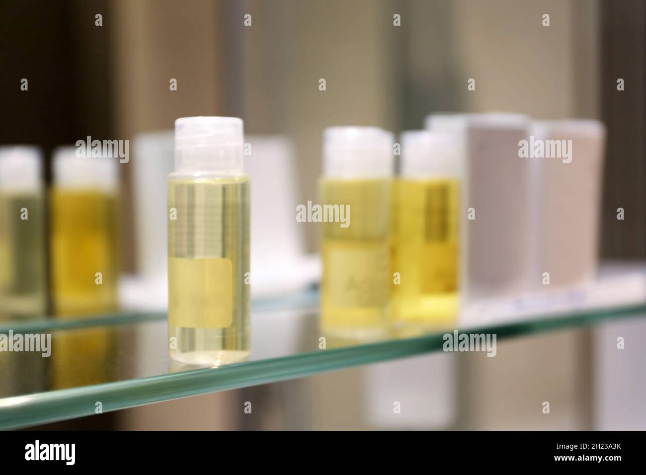Hotel amenities on glass shelf near mirror in bathroom Stock Photo - Alamy